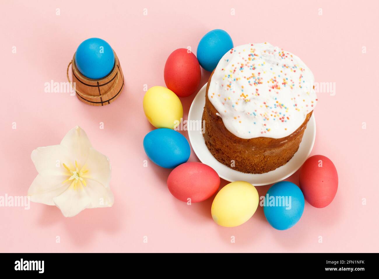 Easter cake on a plate with colorful Easter eggs and a tulip flower on ...