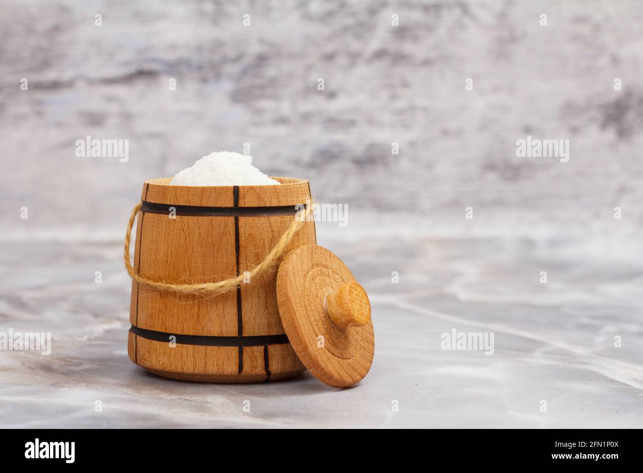 Container for storing salt. Wooden salt cellar on the stone kitchen ...