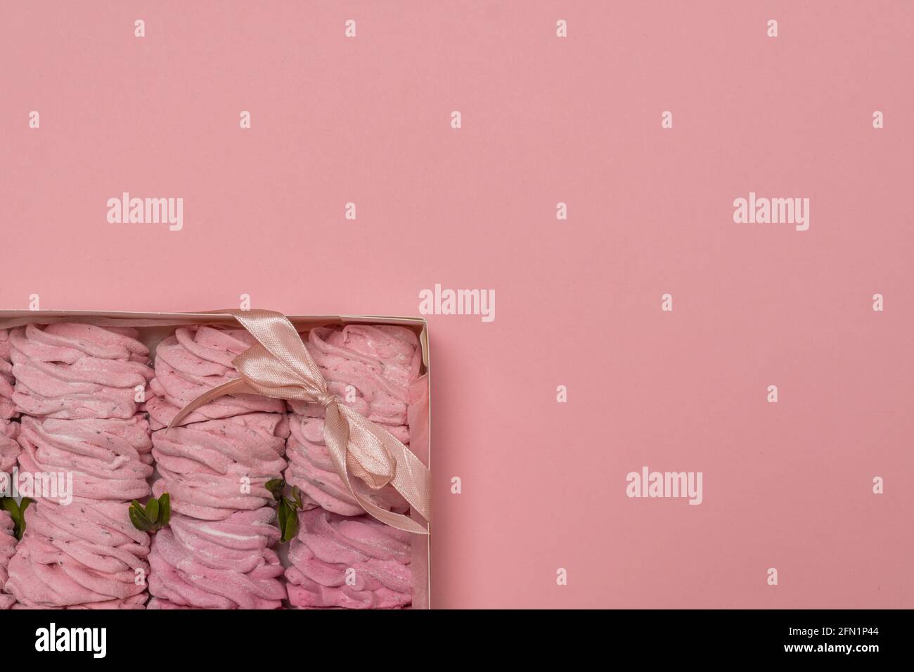 box with marshmallows. pink background. place for text. pink ...