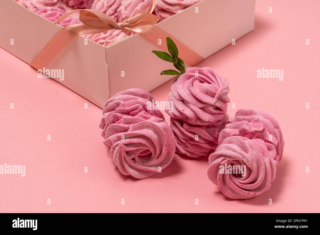 box with marshmallows. pink background. pink marshmallows. space for ...