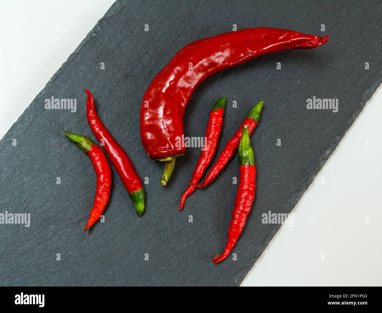 Fresh hot peppers on the stone cutting board. Top view Stock Photo - Alamy