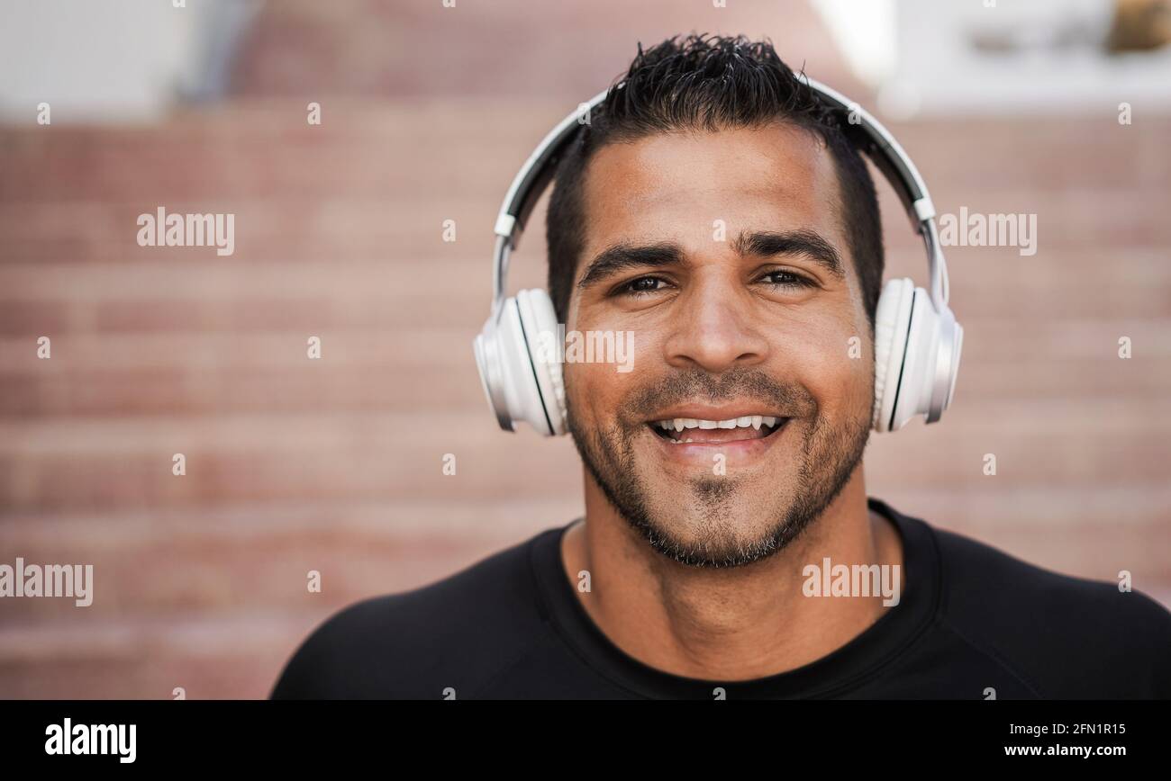 Hispanic man listening music with headphones - Focus on face Stock ...