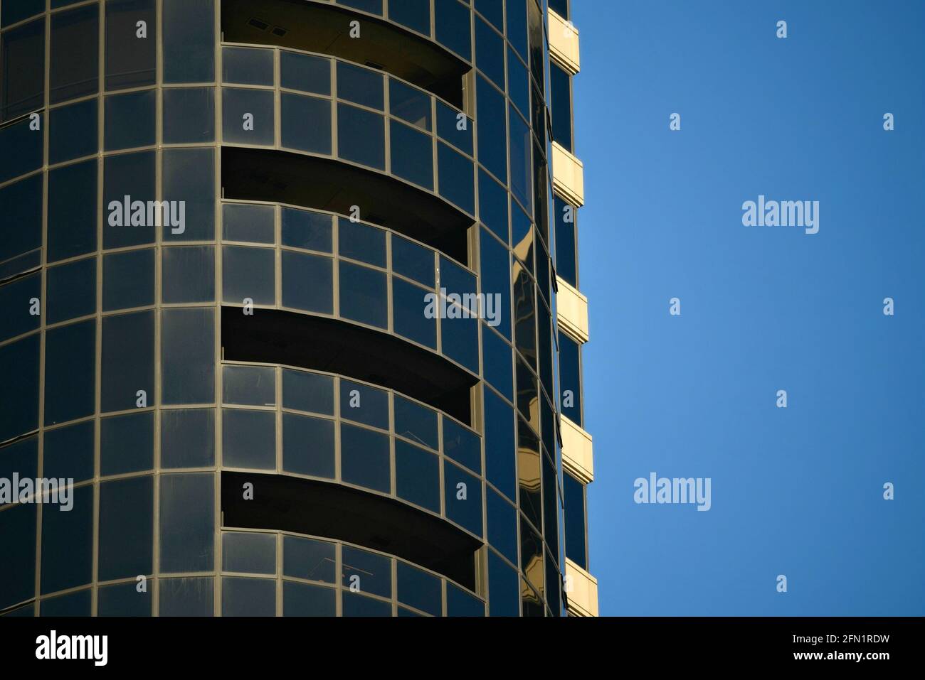 High-rise building cylindrical golden brown glass facade with ...