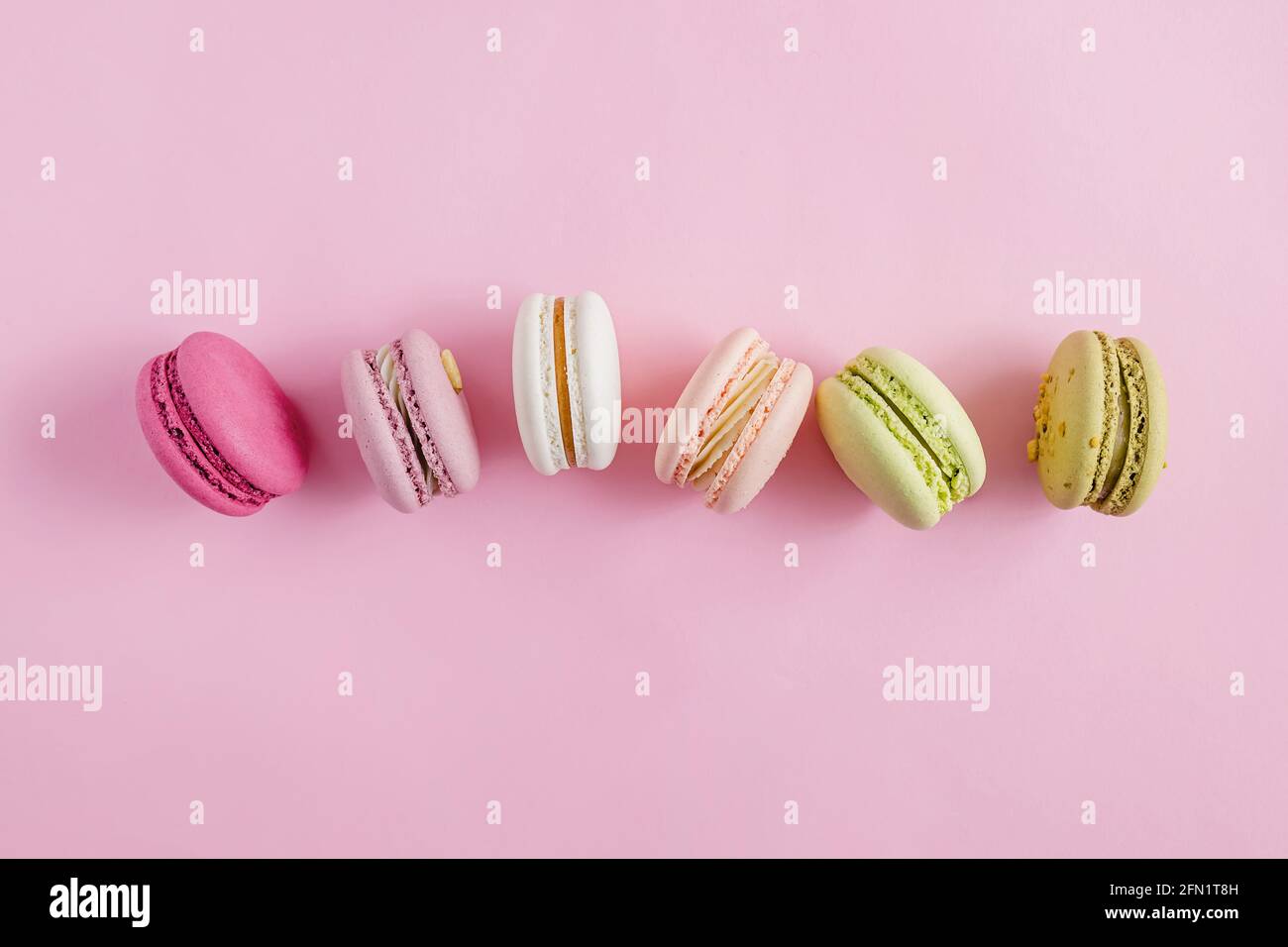 Colorful dessert macarons on pastel pink background Stock Photo - Alamy