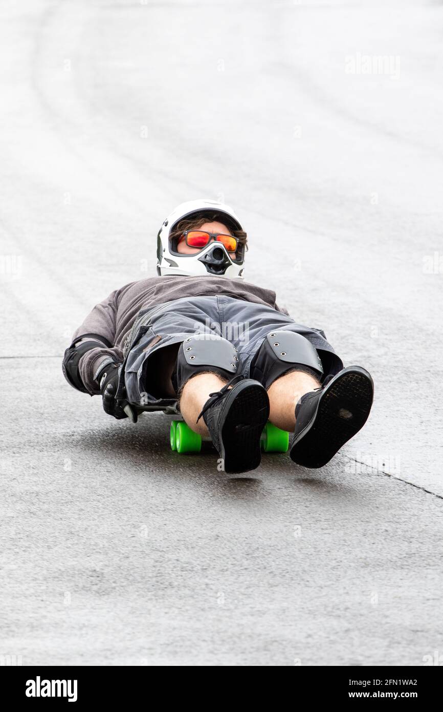 Laying down on a skateboard to go downhill known as buckboarding Stock ...