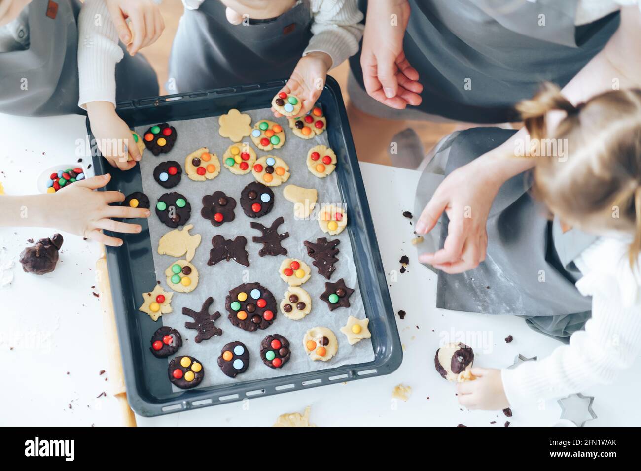 Kids put cookies on baking sheet, hand made cookies Stock Photo - Alamy
