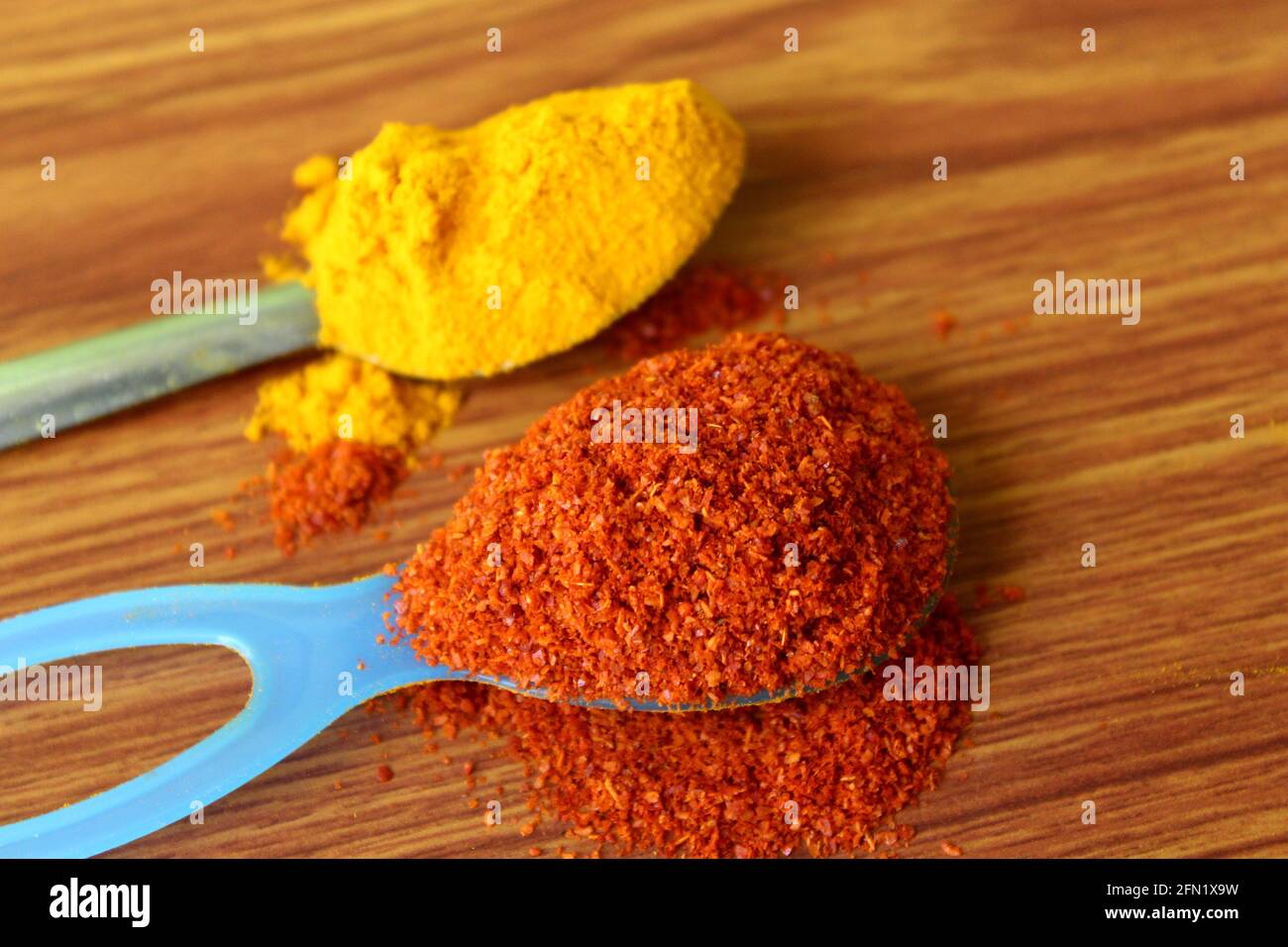 Red chilli powder spice background on wood, selective focus with blur ...