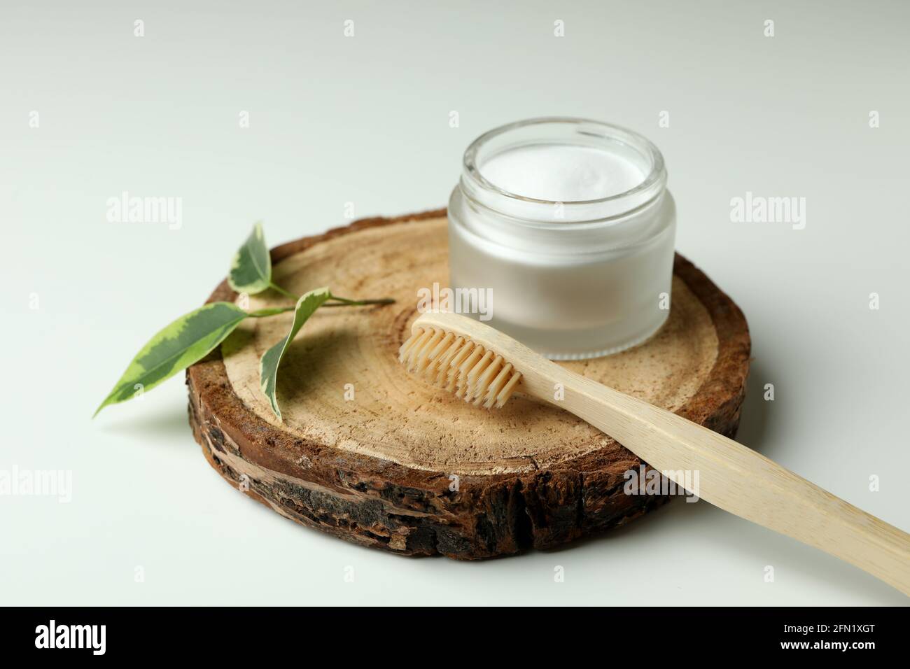 Board with eco friendly toothbrush and tooth powder on white background ...