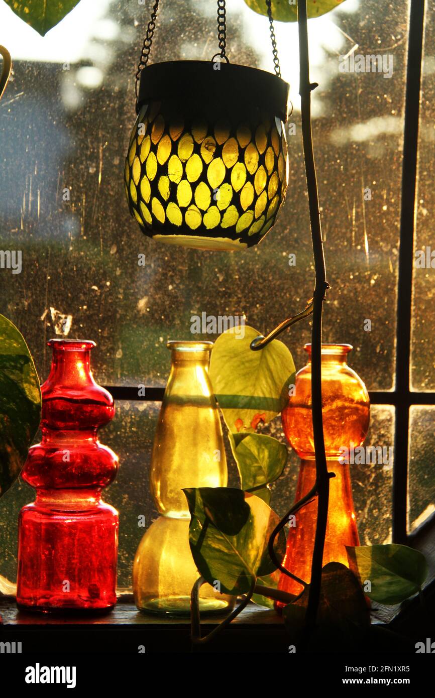 Colorful glass containers by small window Stock Photo - Alamy