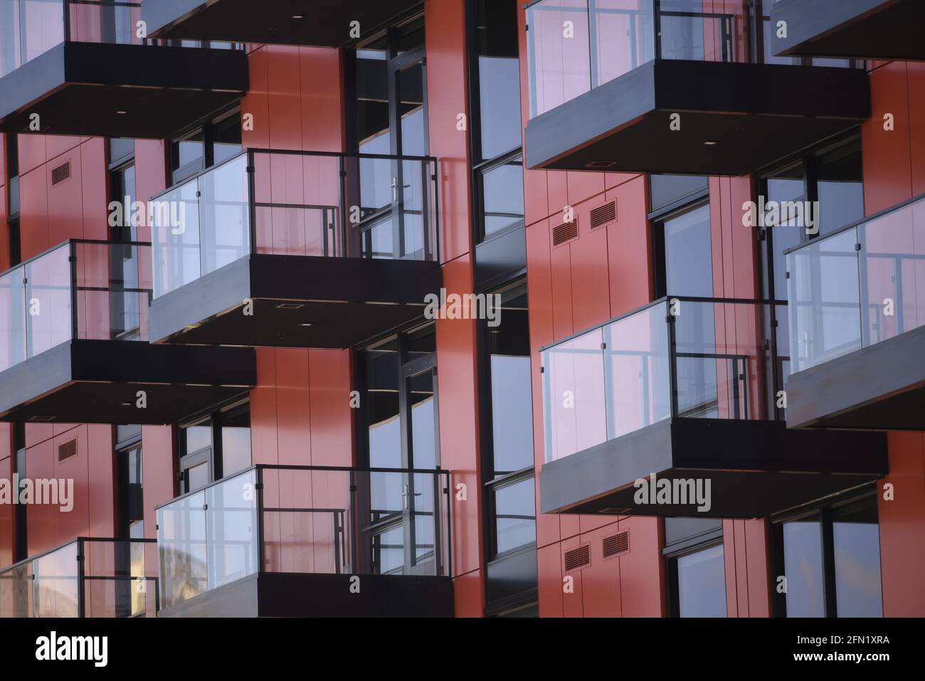 High-rise condominiums complex facade with a red and black cladding and ...