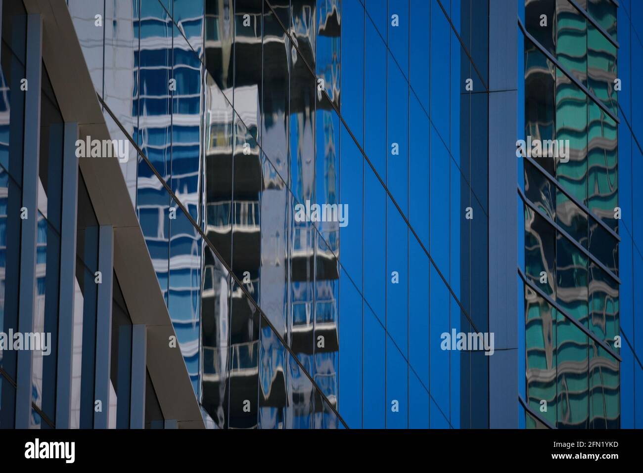 Corporate offices high-rise building blue glass facade with reflections ...