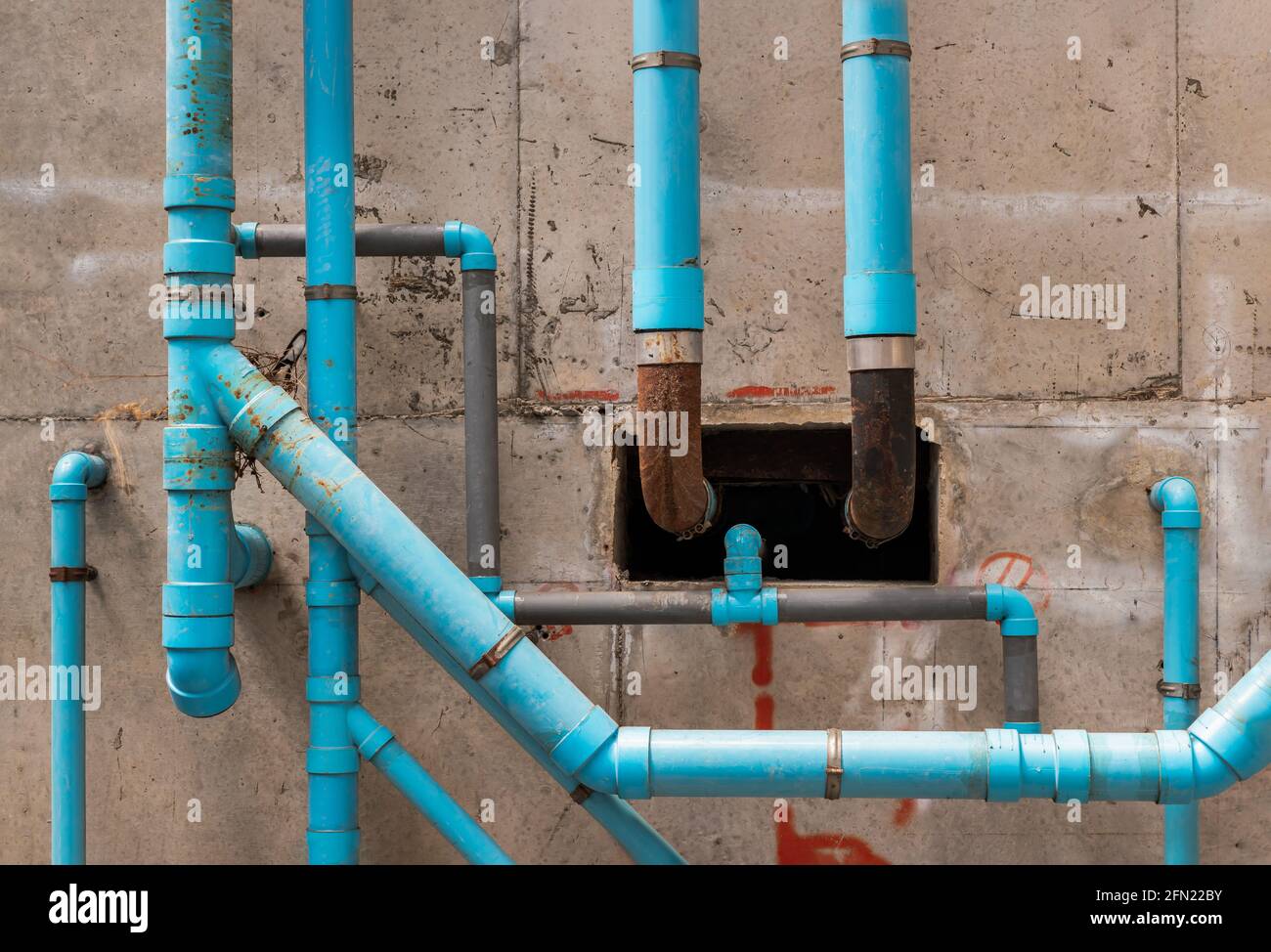 Blue water plastic pipes on the concrete wall in the condominium ...