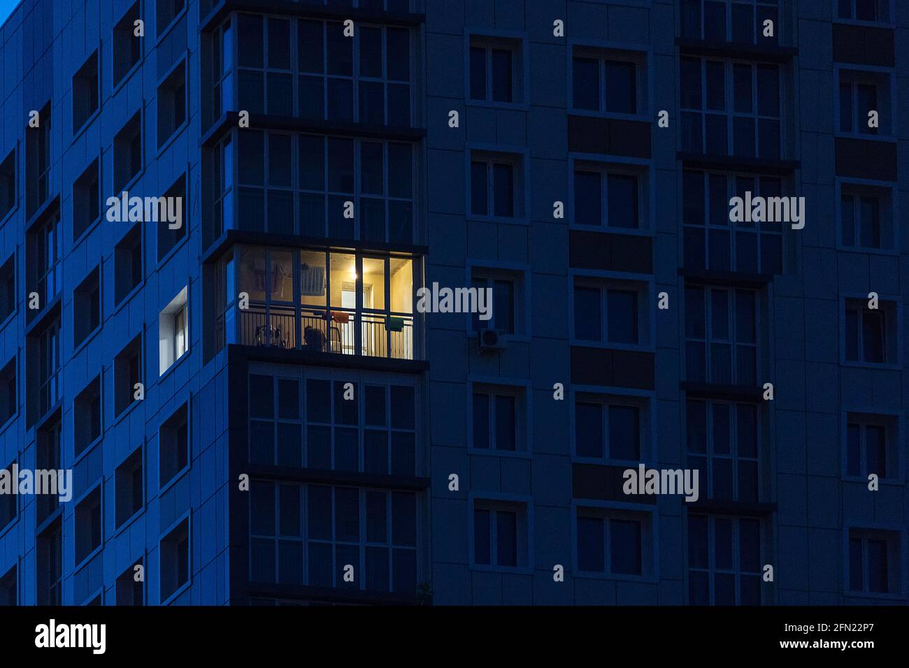 the light burns in one window of the multitude in a multi-storey ...