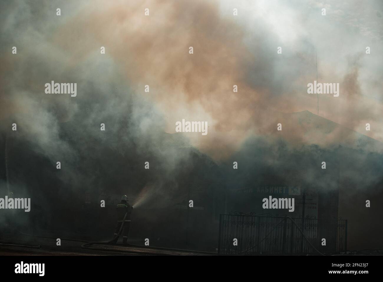 the fire destroys the building. the fire brigade pours water on the ...