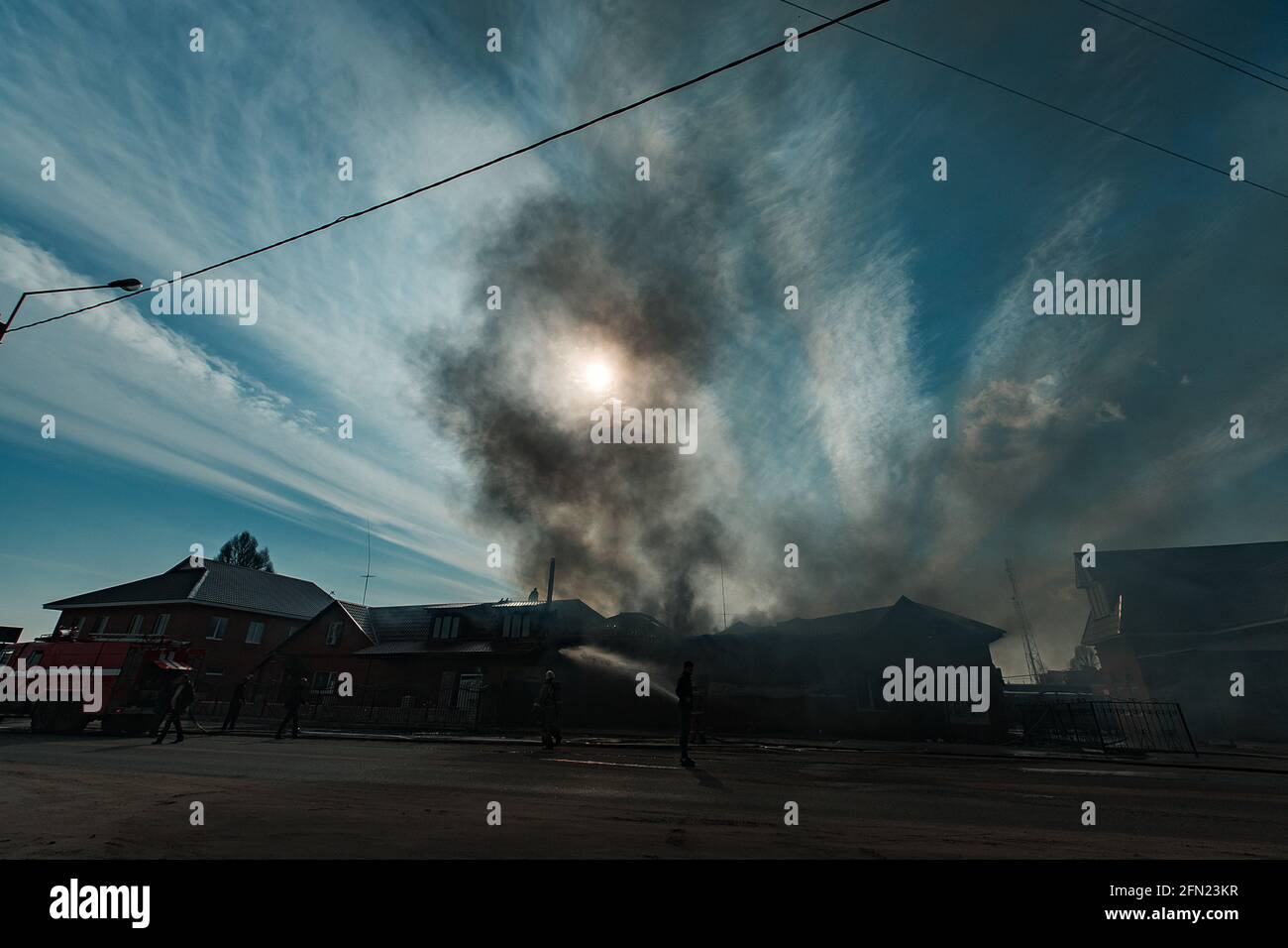the fire destroys the building. the fire brigade pours water on the ...