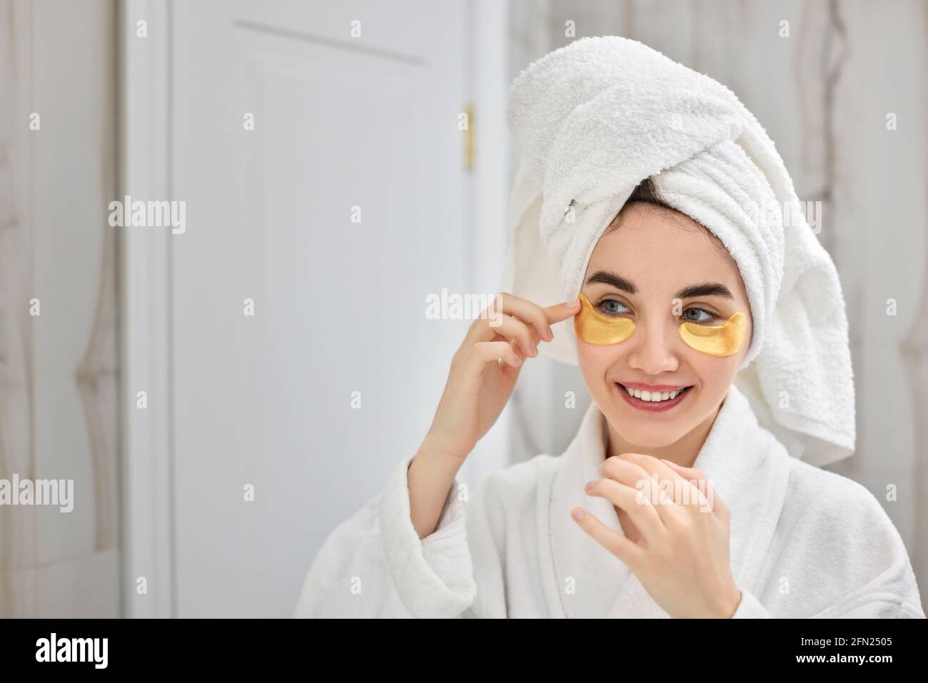 Beautiful Woman With Eye Patches In White Bathrobes In Bathroom Stock