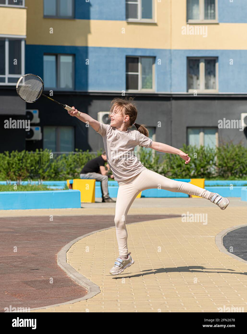 Cute little girl plays in the yard in badminton. activity, healthy ...