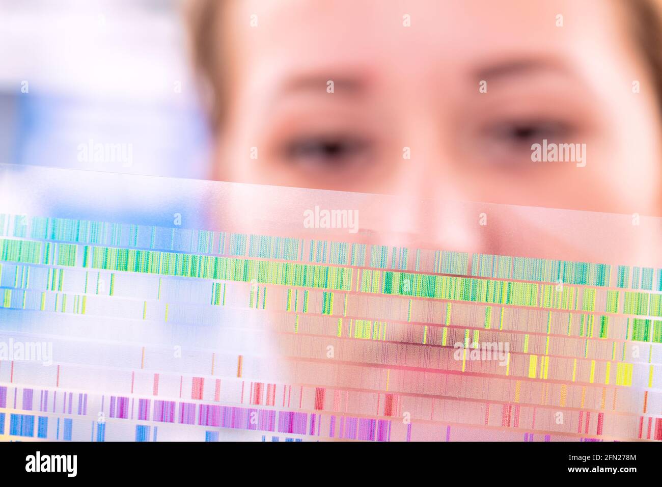 Young woman examines a spectroscopy picture in a quantum physics ...