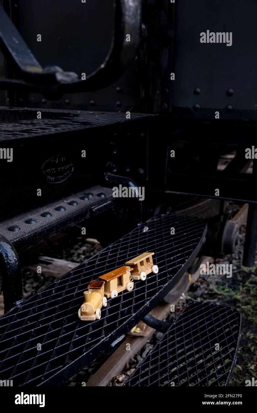 close-up of toy train on steel steps of historic big train Stock Photo ...