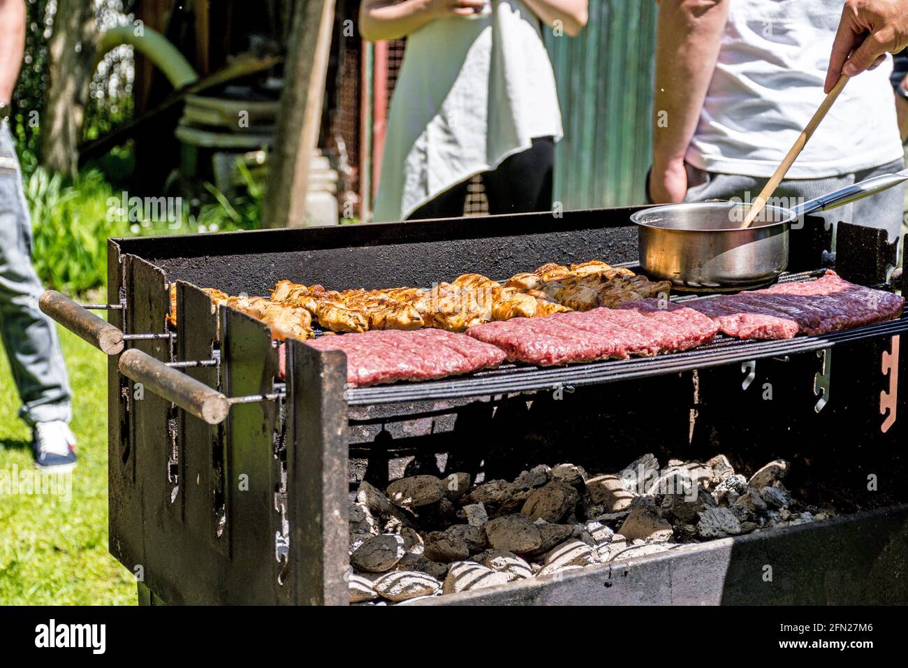 People standing around barbecue grill hi-res stock photography and ...