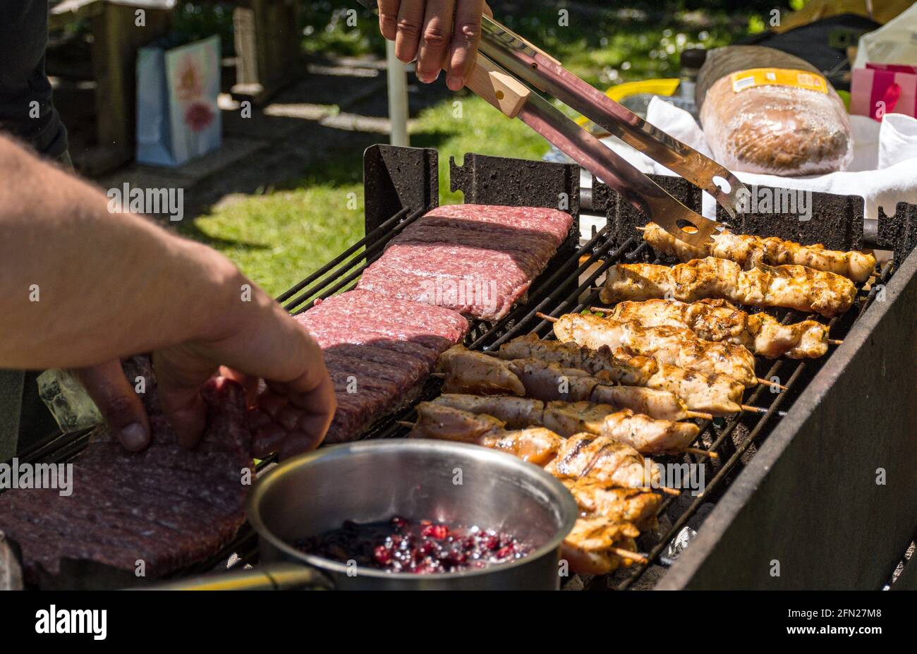 Close-up image of man preparing meat on grill in back yard Stock Photo ...
