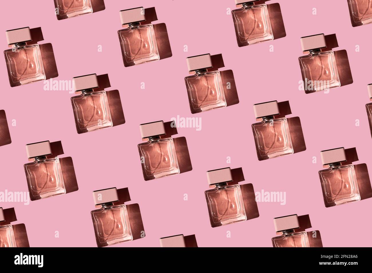 Fragnance parfume pattern. Bottles of pink woman perfume on a pastel ...