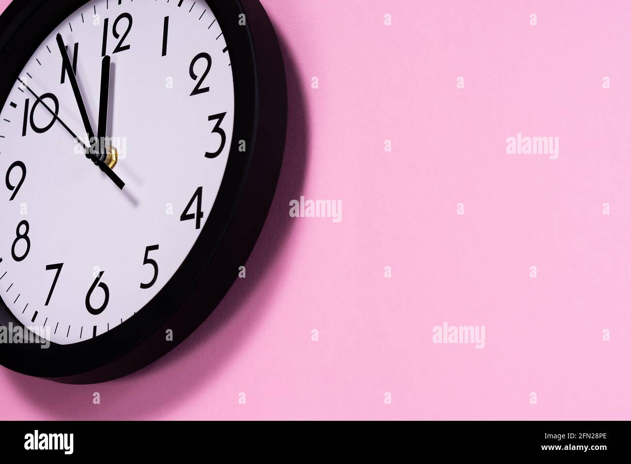 an analog clock on a pink background Stock Photo - Alamy