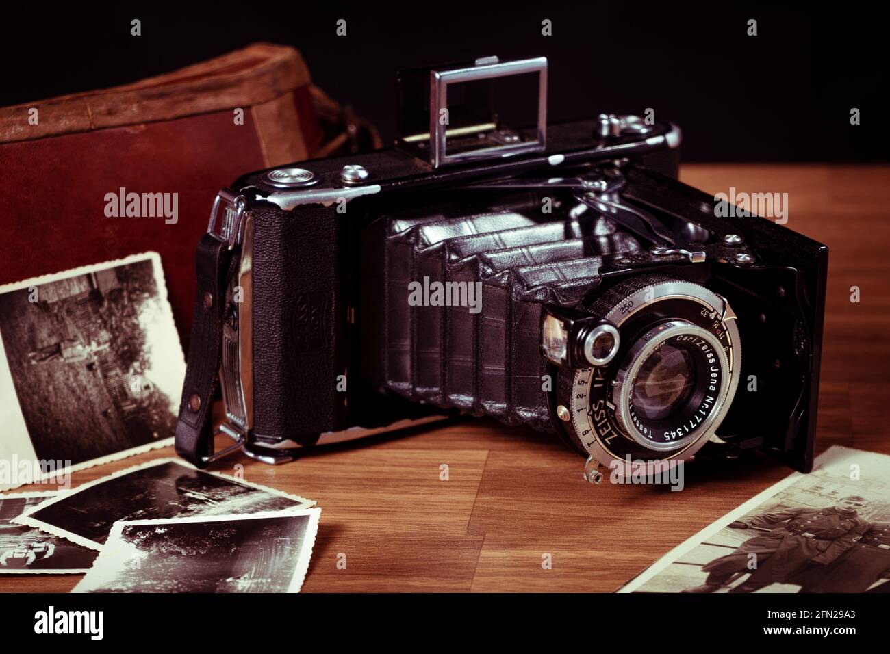 an old camera on a table with old pictures Stock Photo - Alamy