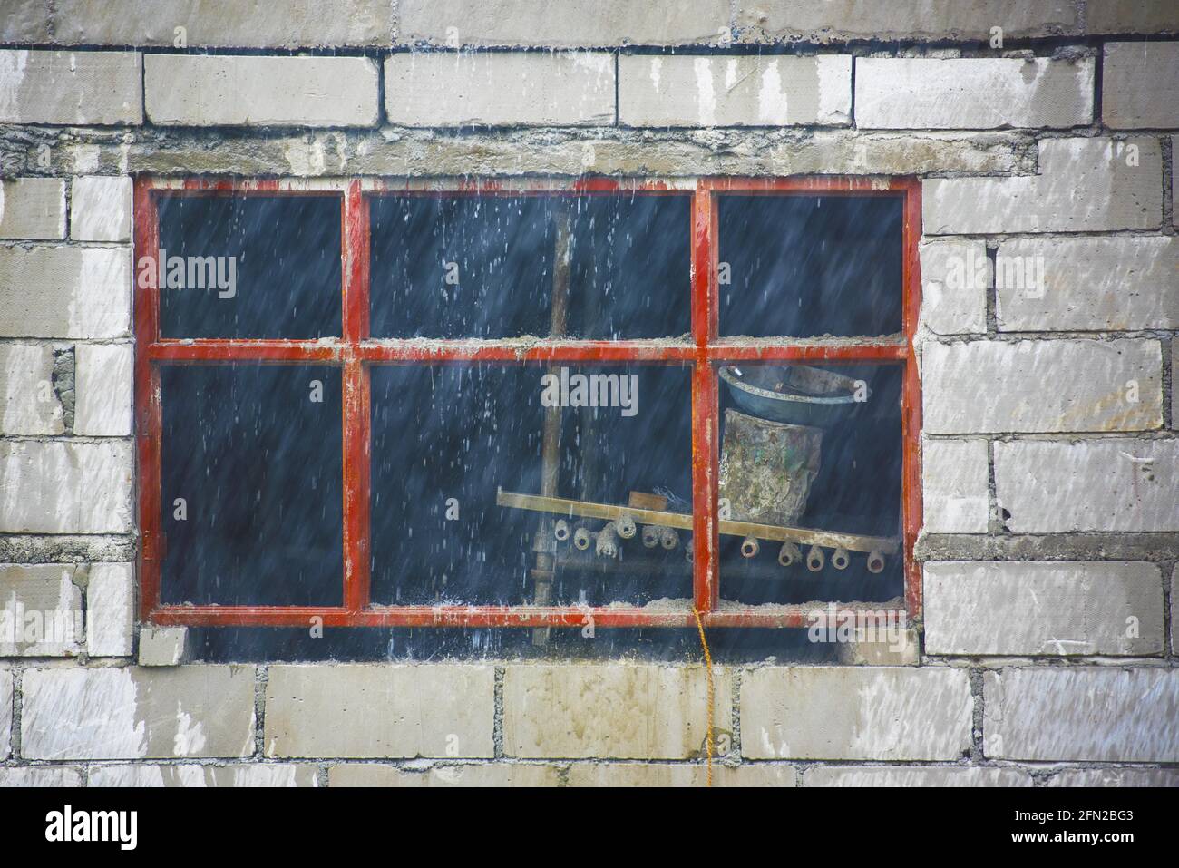Wooden frame on wide windows with rain splashing on it and a metal bowl ...