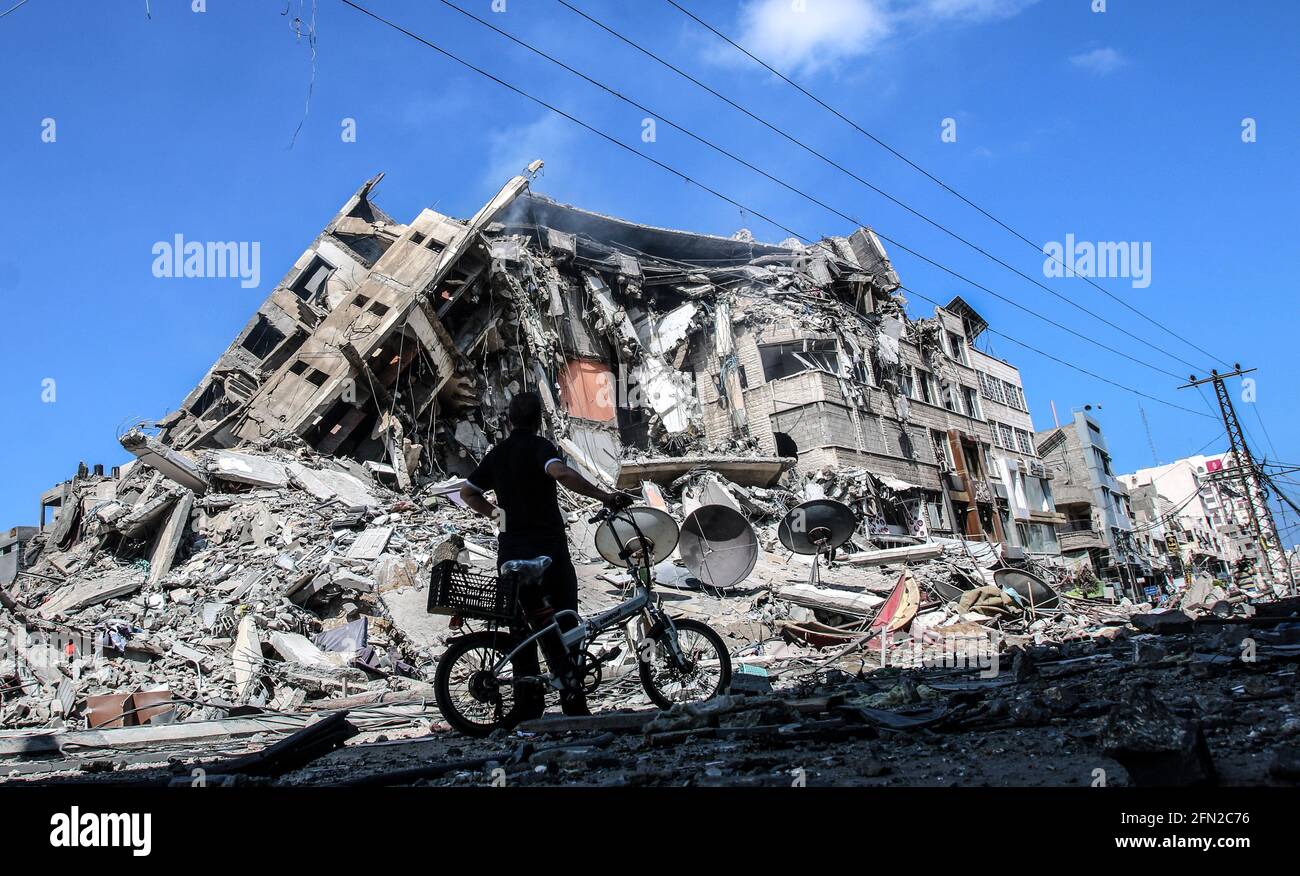 A Palestinian man stands next to Al-Shorouq tower in the aftermath of ...