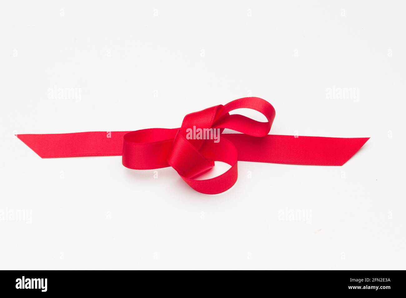 Red ribbon on white background; ribbon used to decorate gifts. A good ...