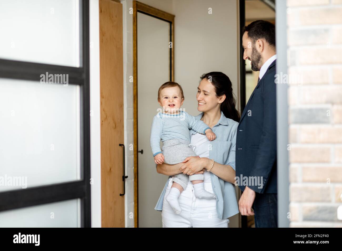Caucasian father saying goodbye to his family before going to work ...