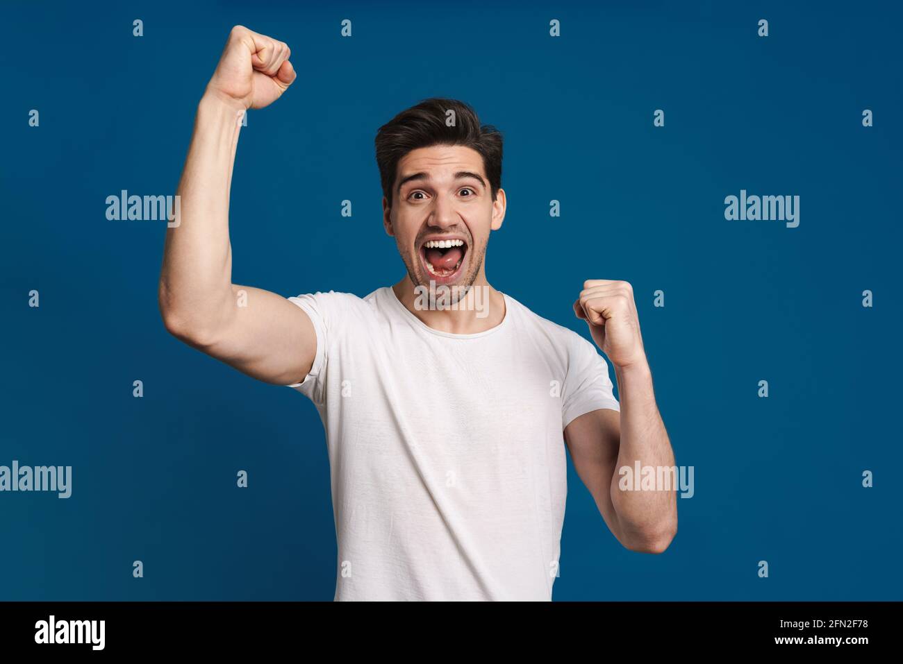 Excited unshaven guy screaming and making winner gesture isolated over ...