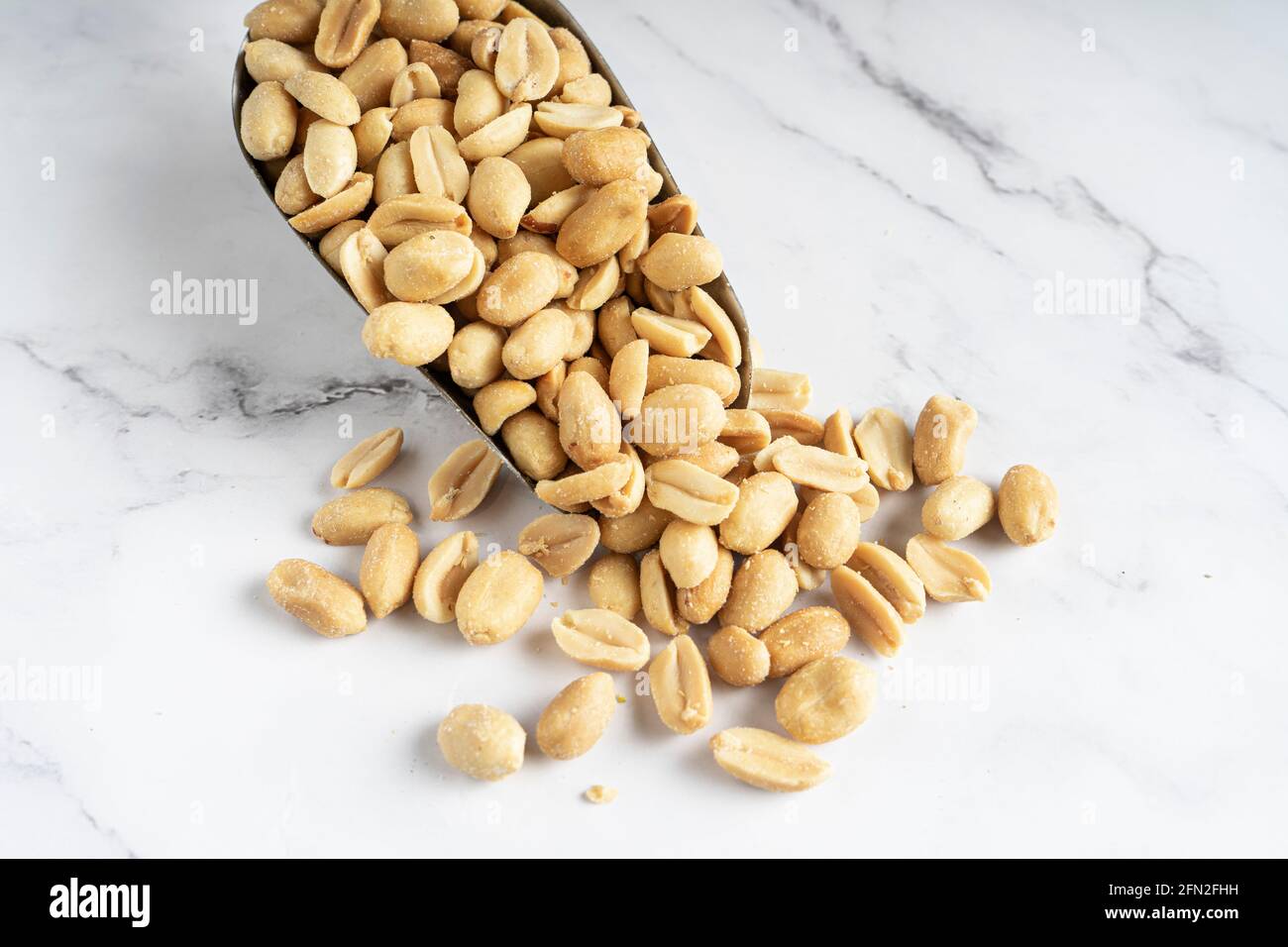Scoop of shelled peanuts on a white marble background. Isolated Stock ...