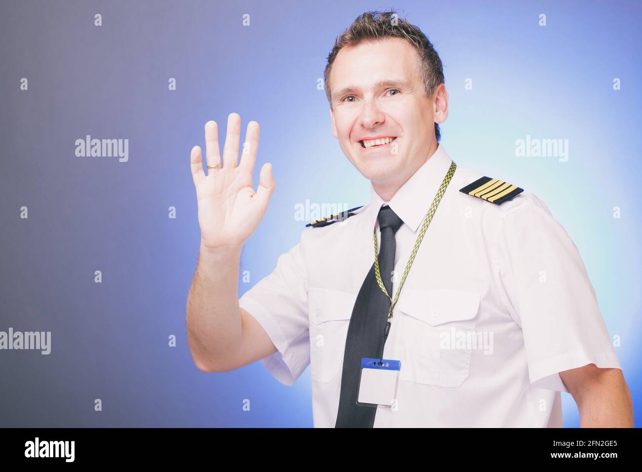 Mature smiling male pilot waving hand Stock Photo - Alamy