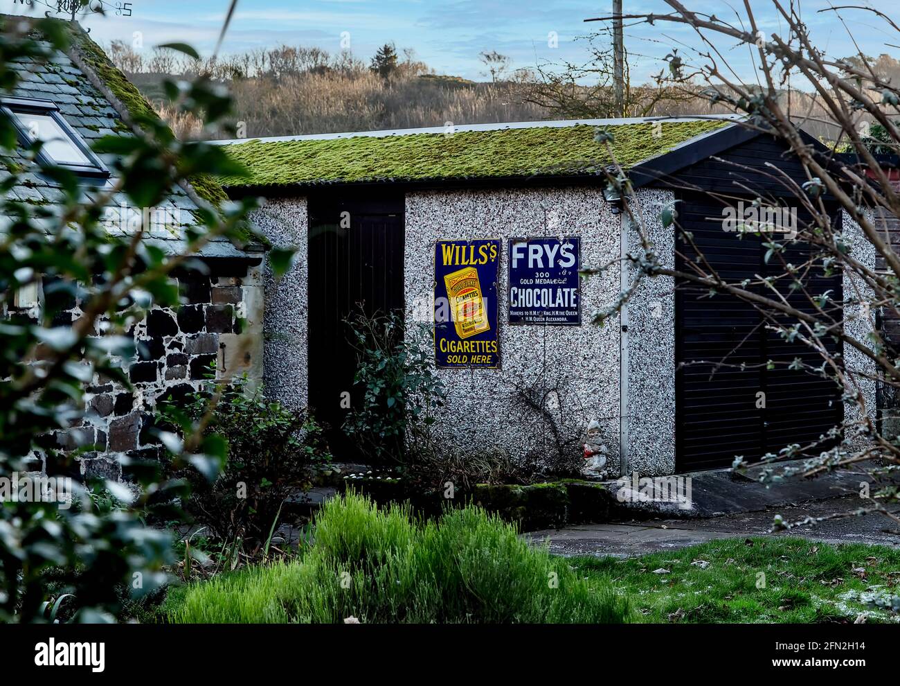 Garden shed in rural England with old metal advertising posters Stock ...