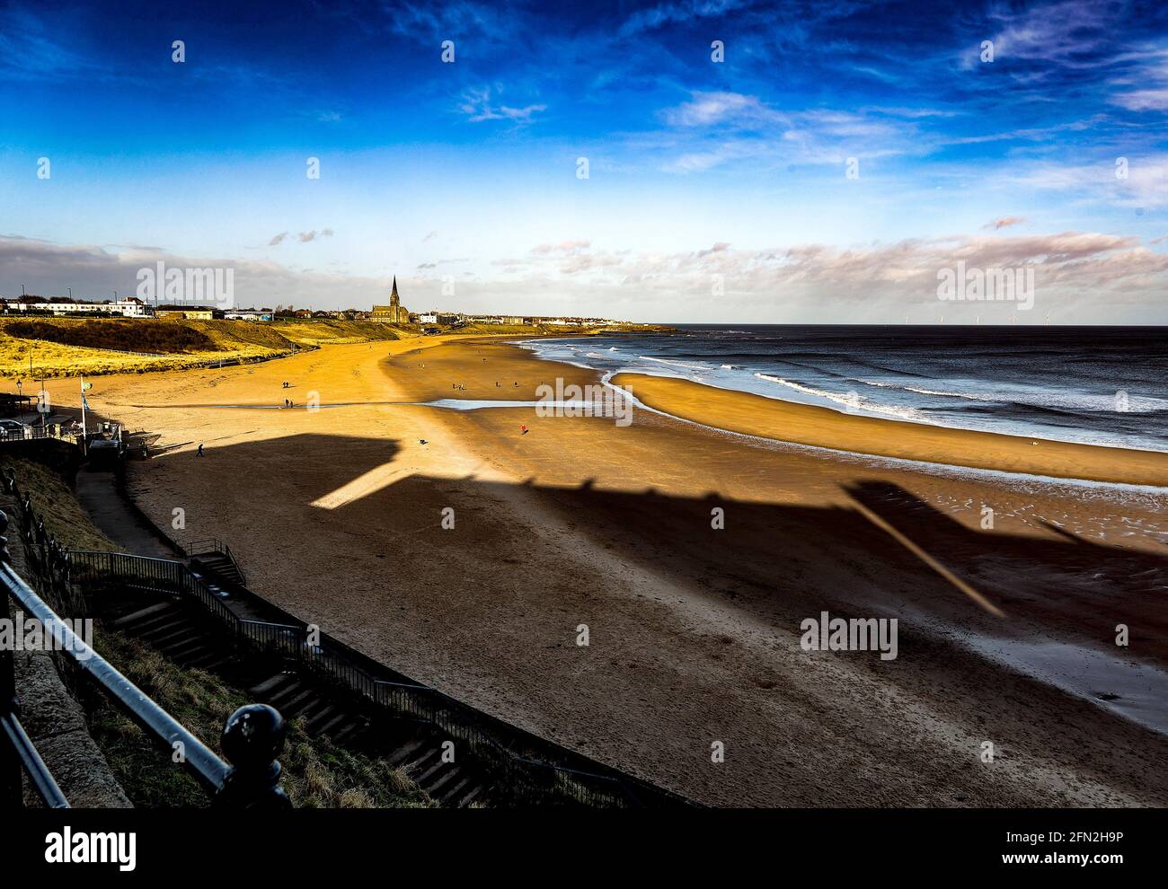 Deep shadows creep over the Long Sands at Tynemouth, in the North of England Stock Photo - Alamy