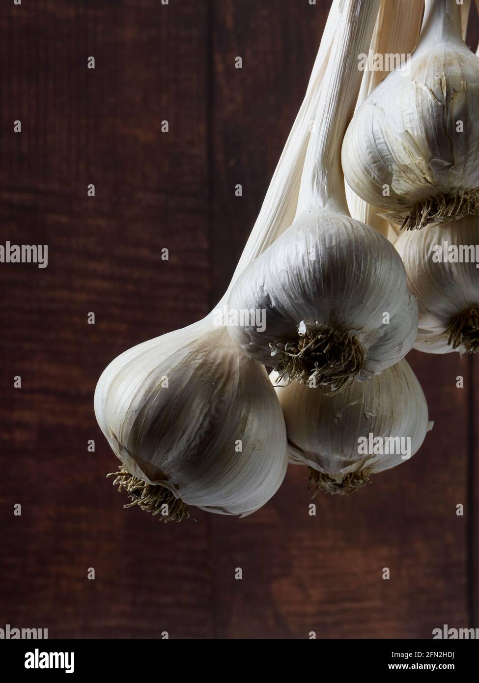 The harvest of a bunch of garlic hung drying and spinning slowly Stock ...
