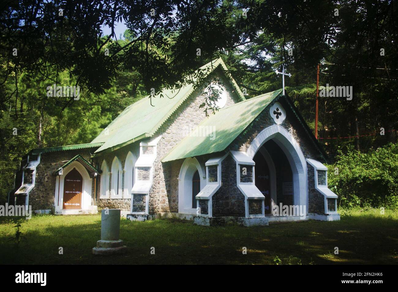 Humble church with sunlight shining on its roof in a thick forest Stock ...