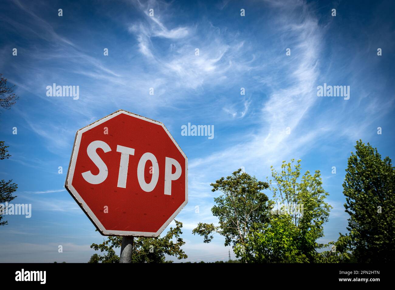 Close-up of a Stop Road Sign on blue sky with clouds and copy space ...