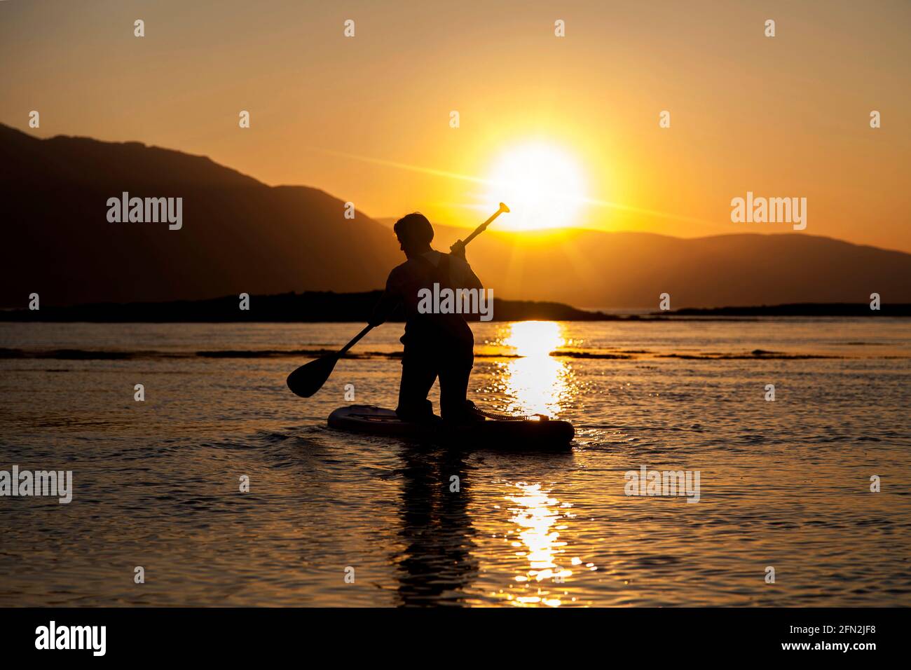 Paddle boarding sunsets Stock Photo - Alamy