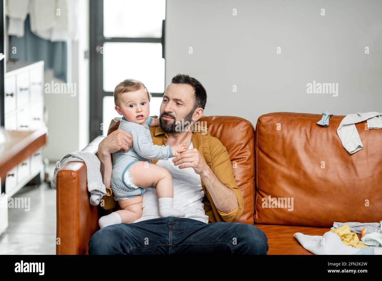 Middle aged dad carrying and playing with newborn baby alone at home ...