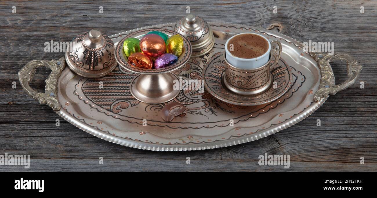 Pouring Turkish coffee into vintage cup on wooden background. Turkish ...