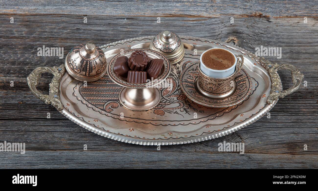 Pouring Turkish coffee into vintage cup on wooden background. Turkish ...