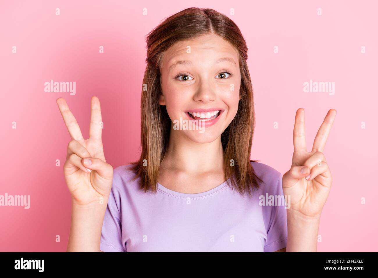 Photo of cheerful cute happy little girl make fingers v-signs isolated ...