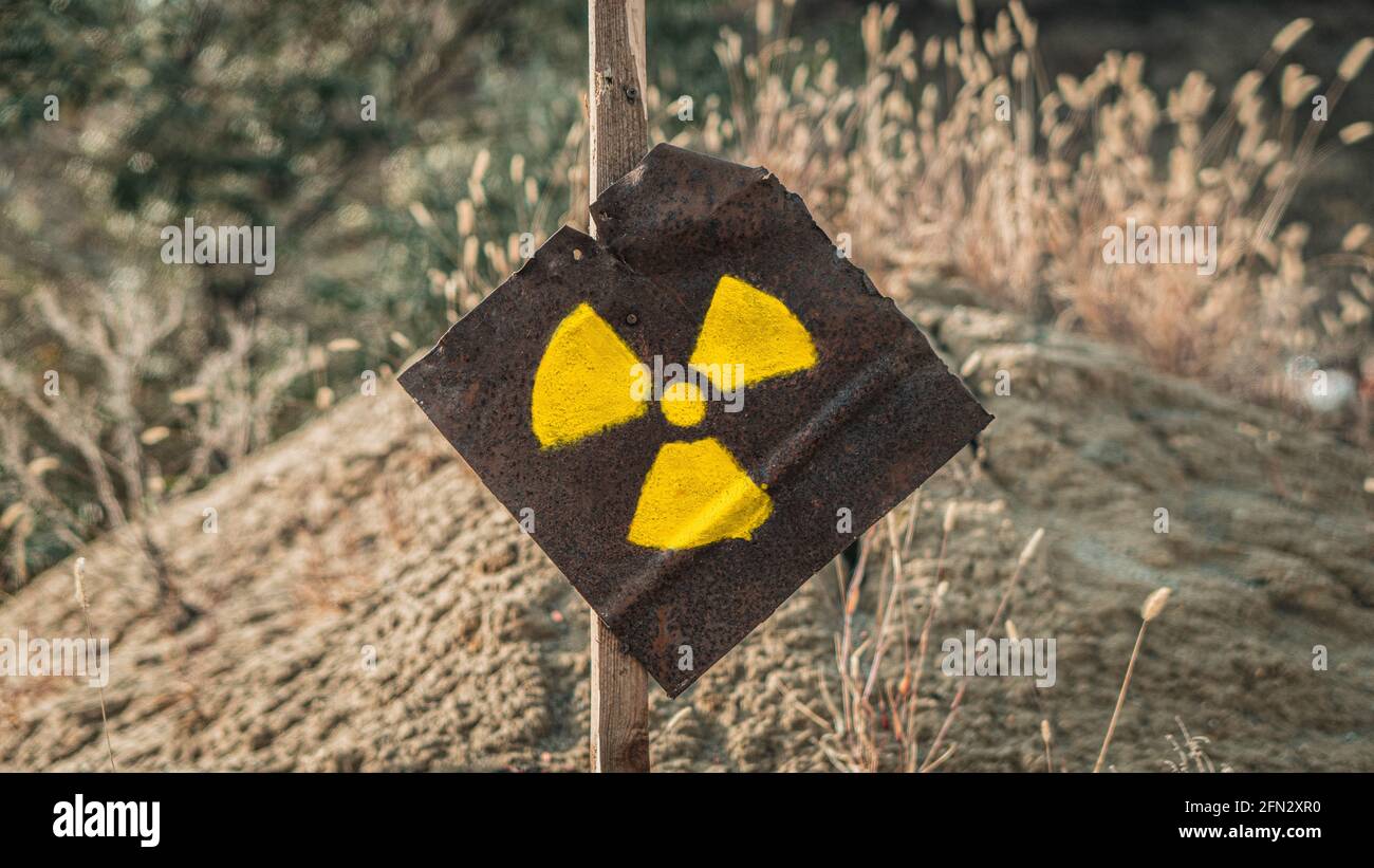Radiation sign on a rusty metal plate. Hazard warning. Post-apocalyptic ...