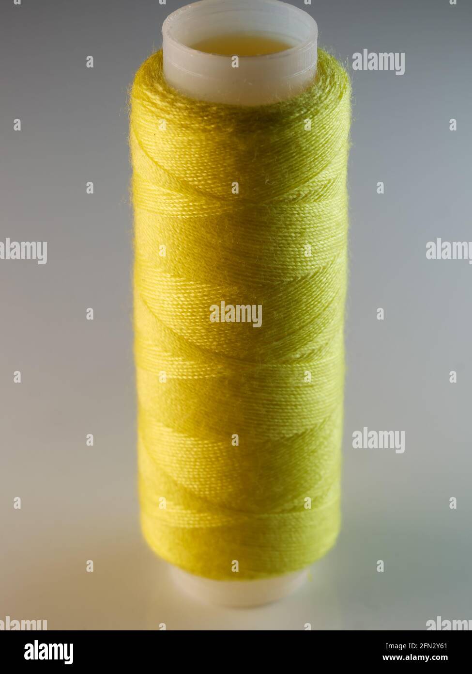 Vertical shot of a yellow sewing thread Stock Photo - Alamy