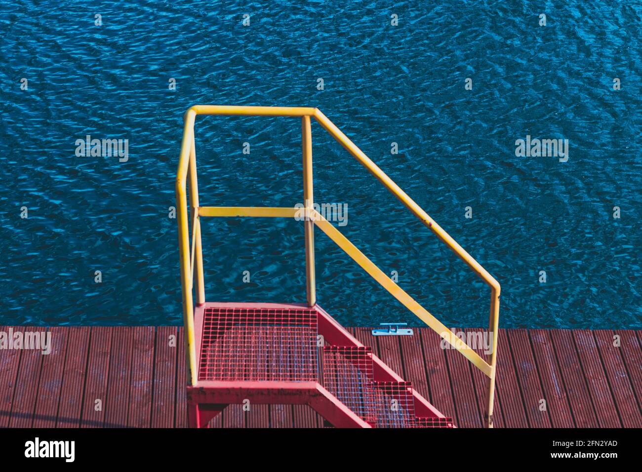 red stairs with a yellow railing leading to the pier Stock Photo - Alamy