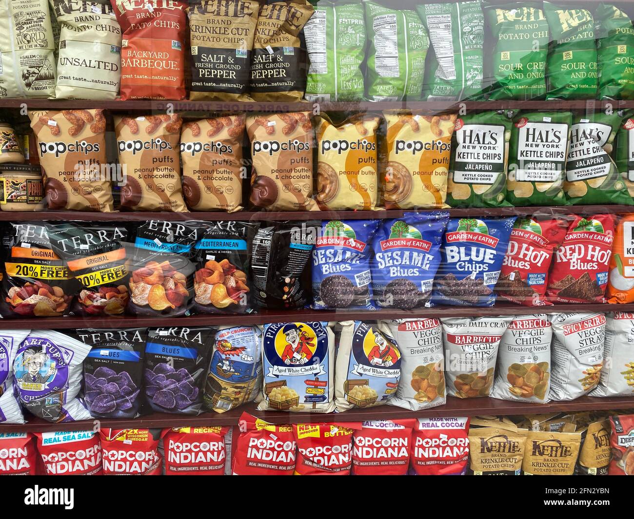 Deli-grocery window displaying a variety of brands of chips a most ...