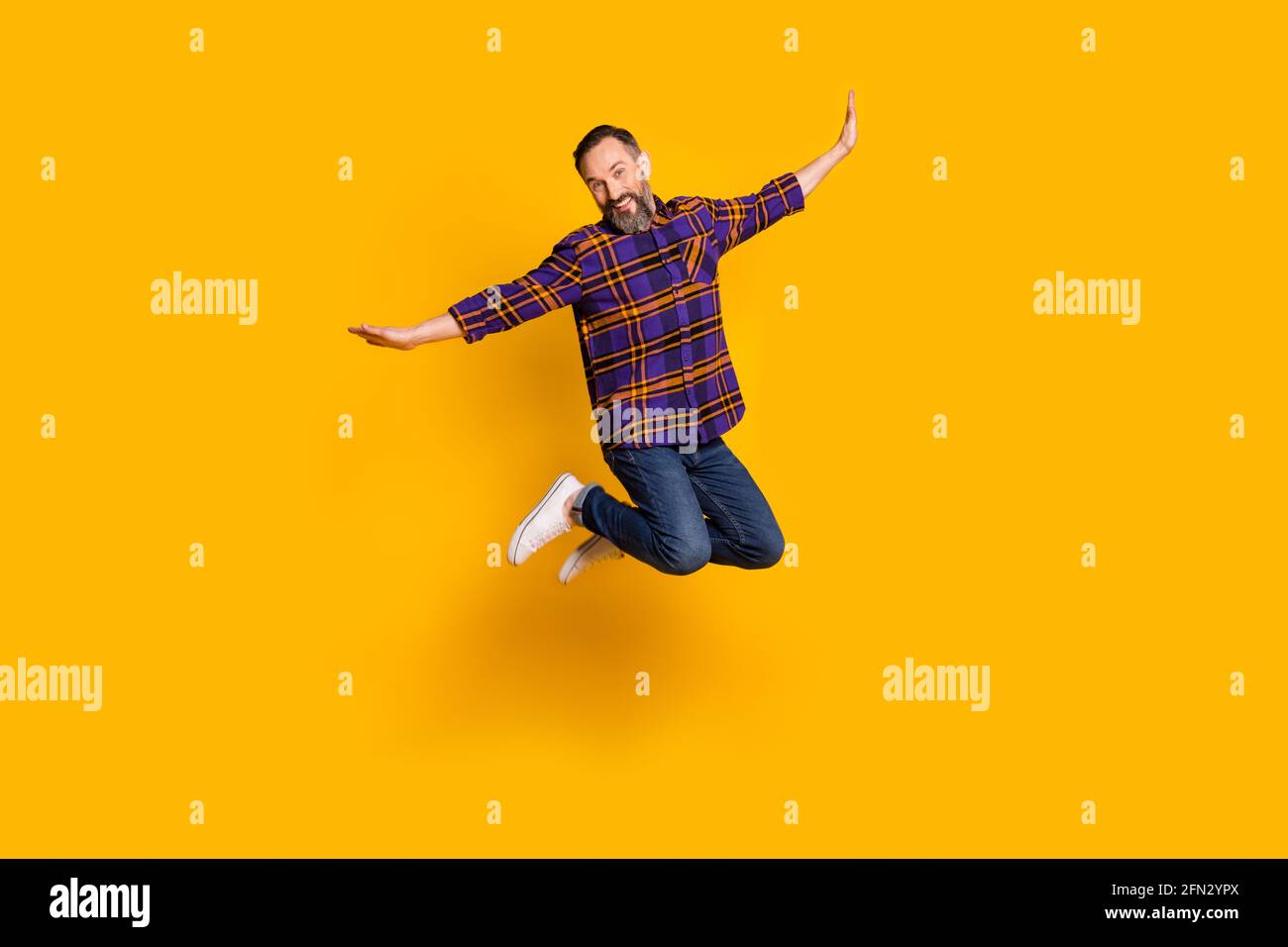 Full body photo of joyful positive happy man jump up air make hands ...